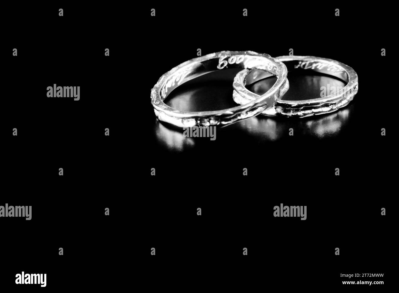 two white gold rings stacked together on black background Stock Photo ...