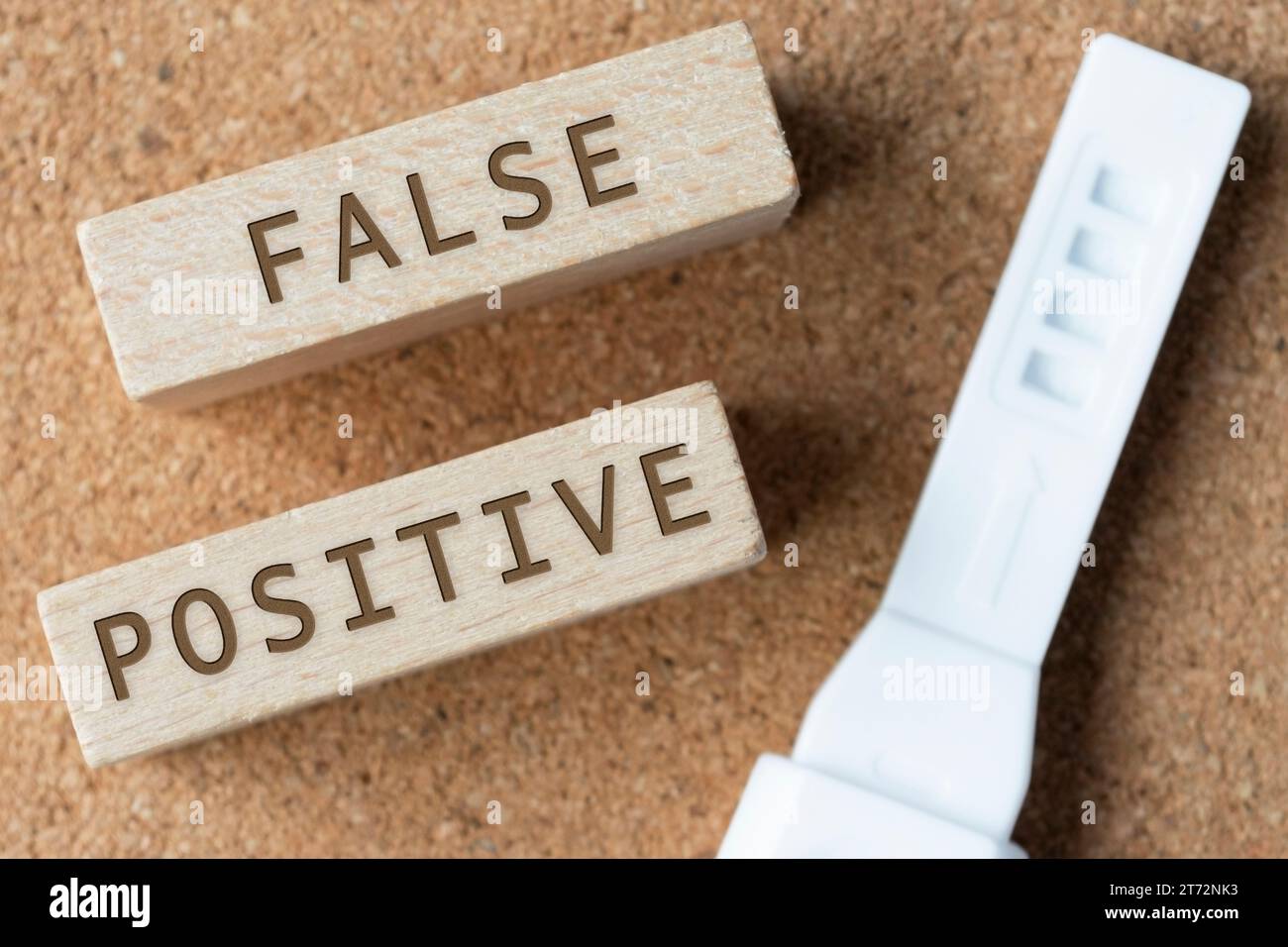 False positive words on wooden block with pregnancy test kit Stock ...