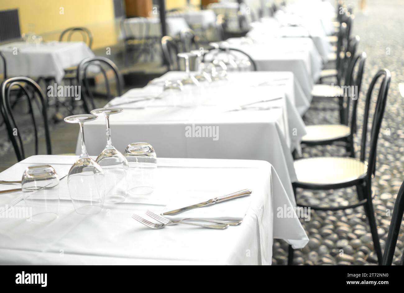 Elegant Restaurant tables in row terrace and rustic grey stone street ...