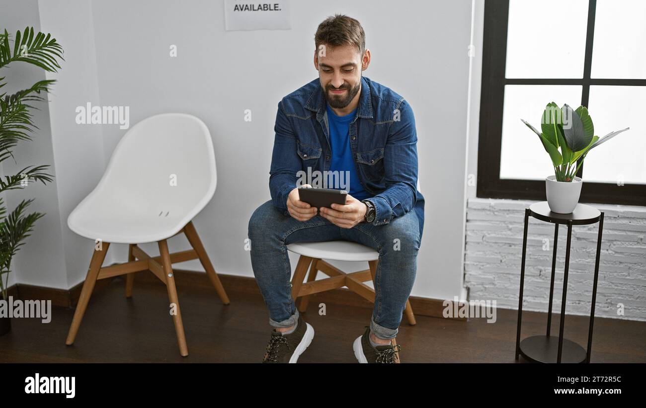 Cheery young hispanic guy, sitting relaxed in a chair, confidently ...