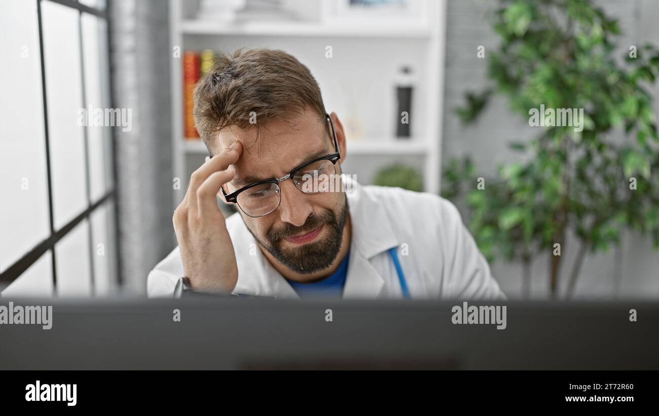 Stressed out young hispanic man doctor working tirelessly at clinic ...
