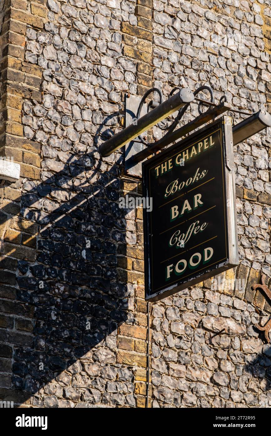 Sign hanging on a stone, flint wall for The Chapel Public house Stock ...
