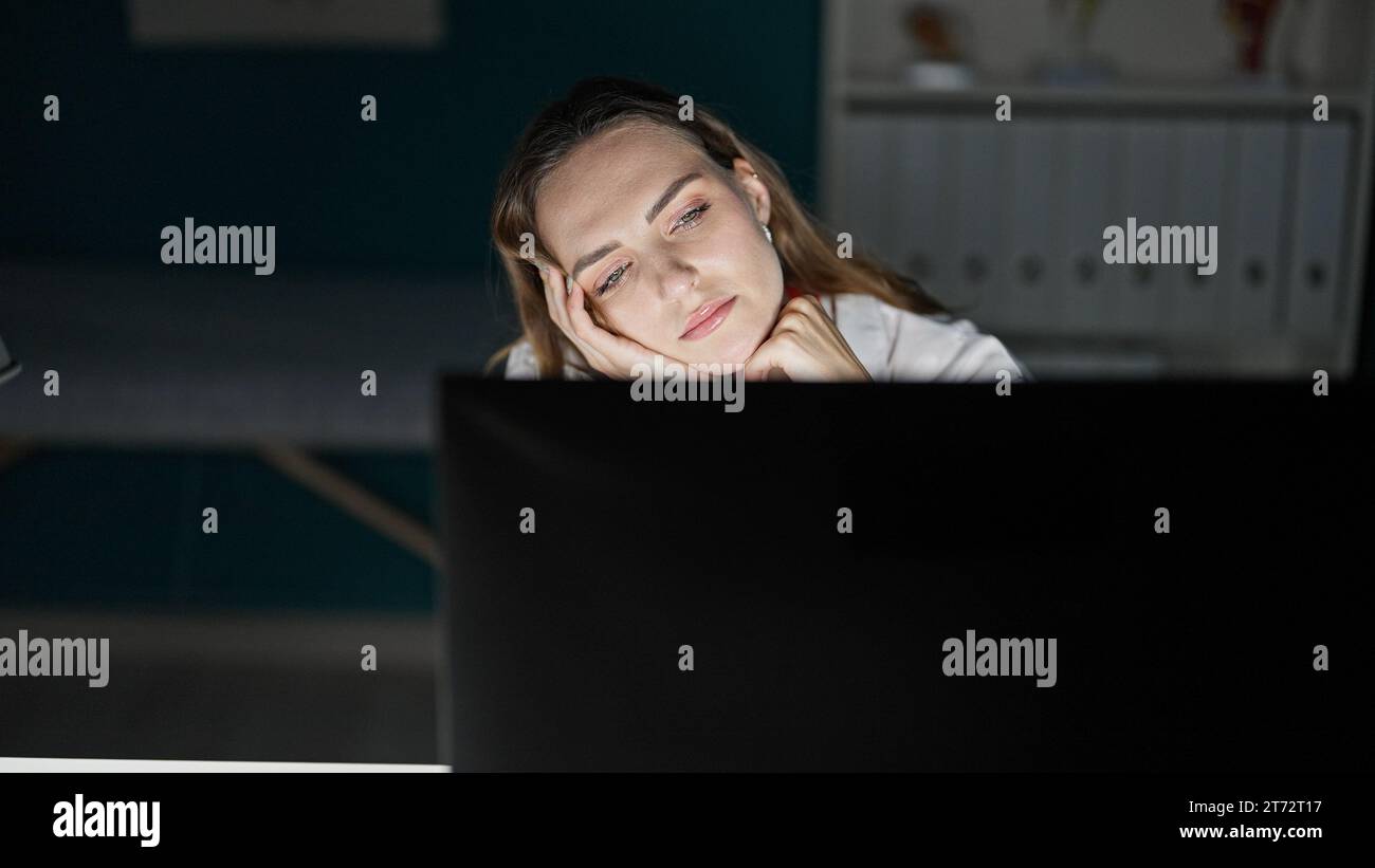 Young blonde woman doctor tired using computer working at clinic Stock ...
