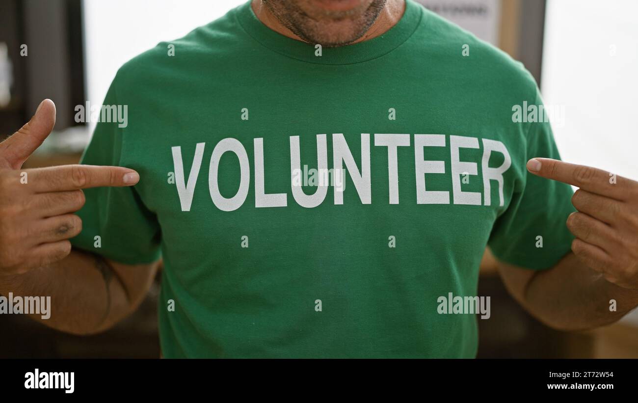 Man's hands earnestly pointing at volunteer uniform in charity center ...
