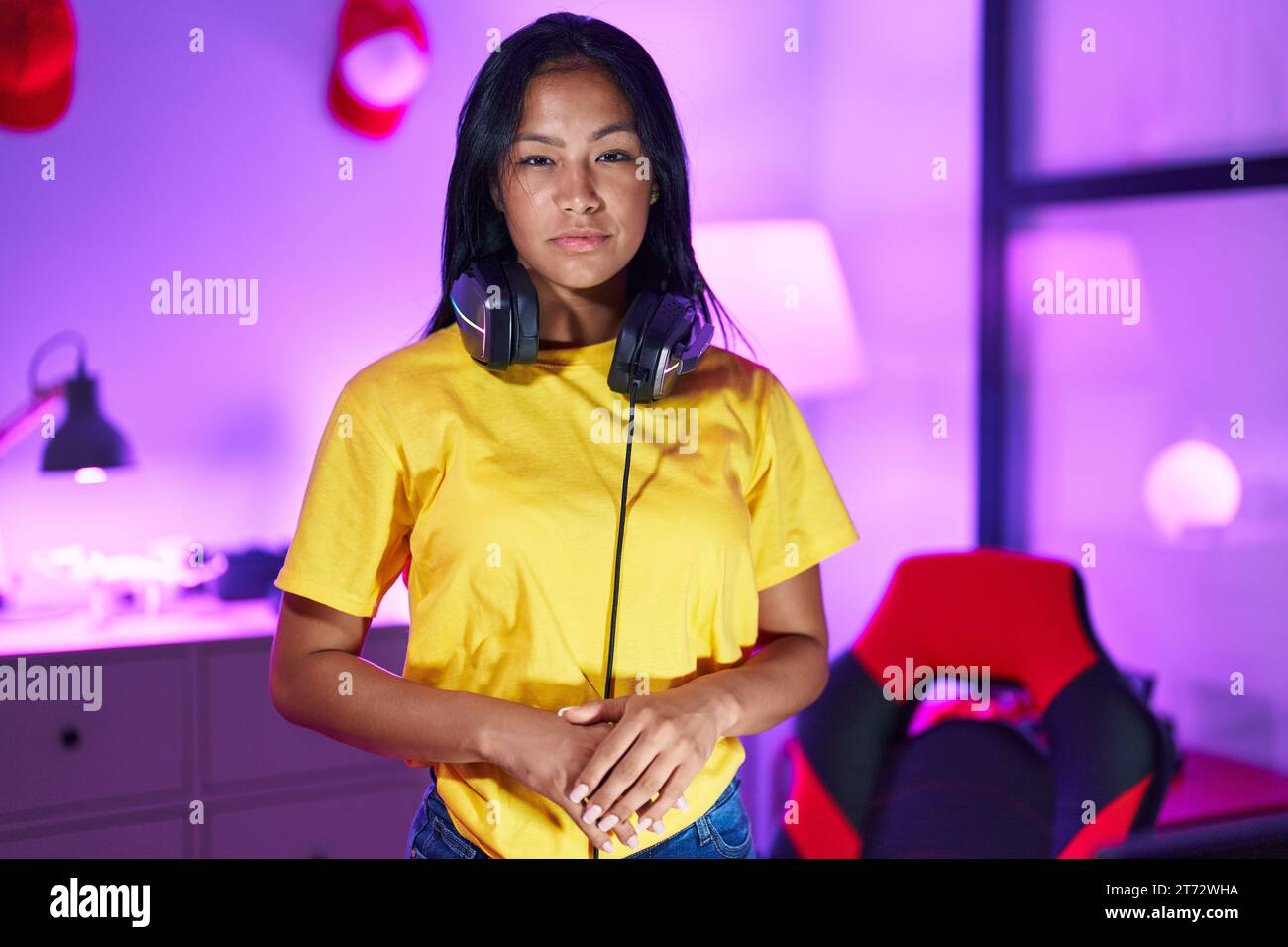 Young beautiful latin woman streamer standing with serious expression ...