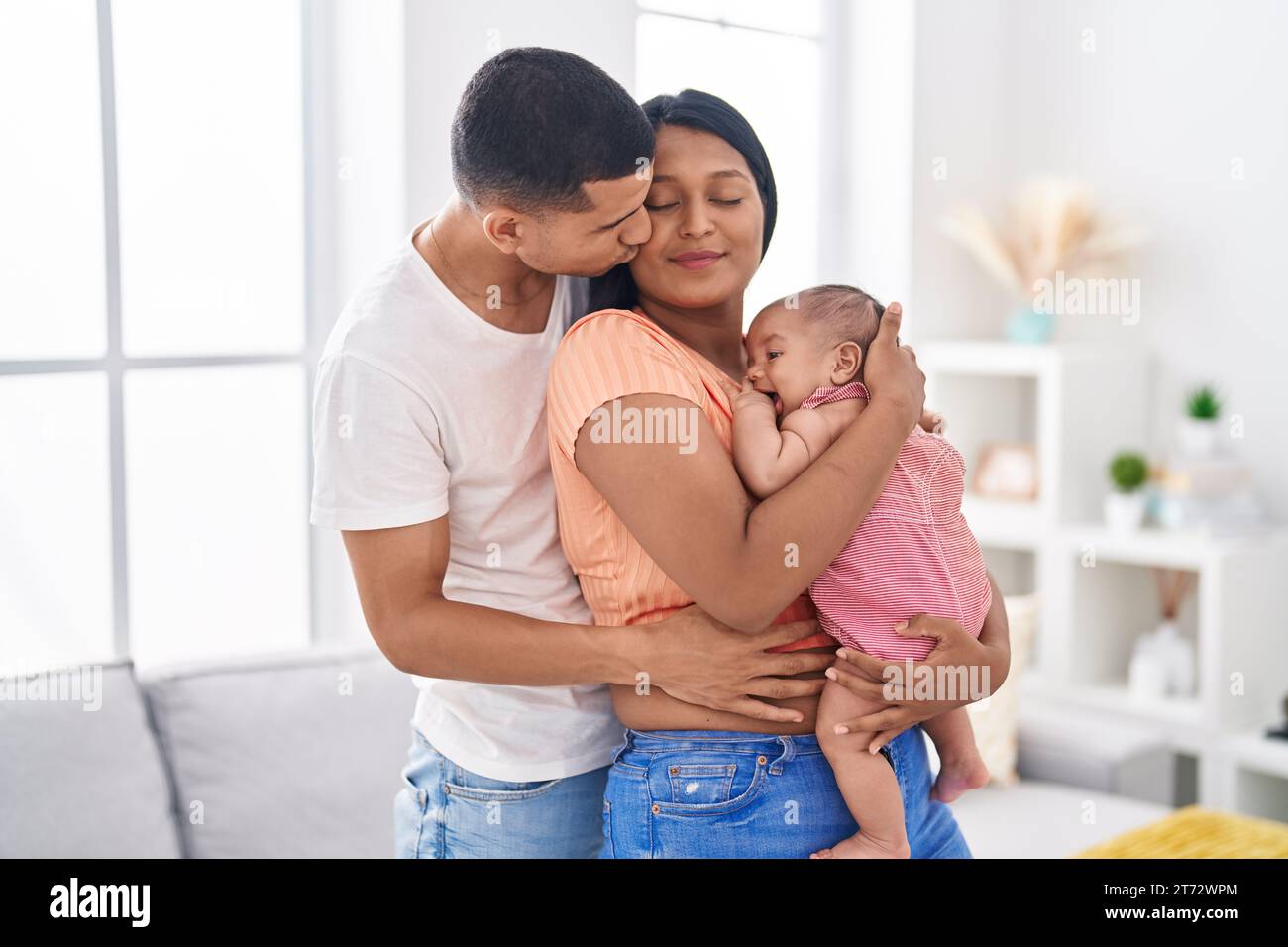 Hispanic family hugging each other kissing at home Stock Photo - Alamy