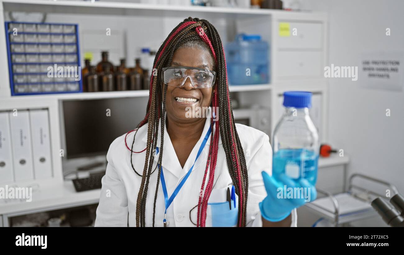 Confident african american female scientist with braids smiling as she ...