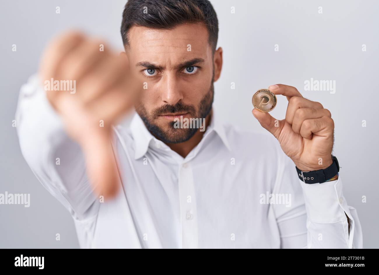 Handsome hispanic man holding polkadot cryptocurrency coin with angry ...
