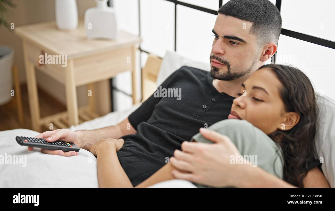 Beautiful couple in love, lying together on the comfy bed in their ...