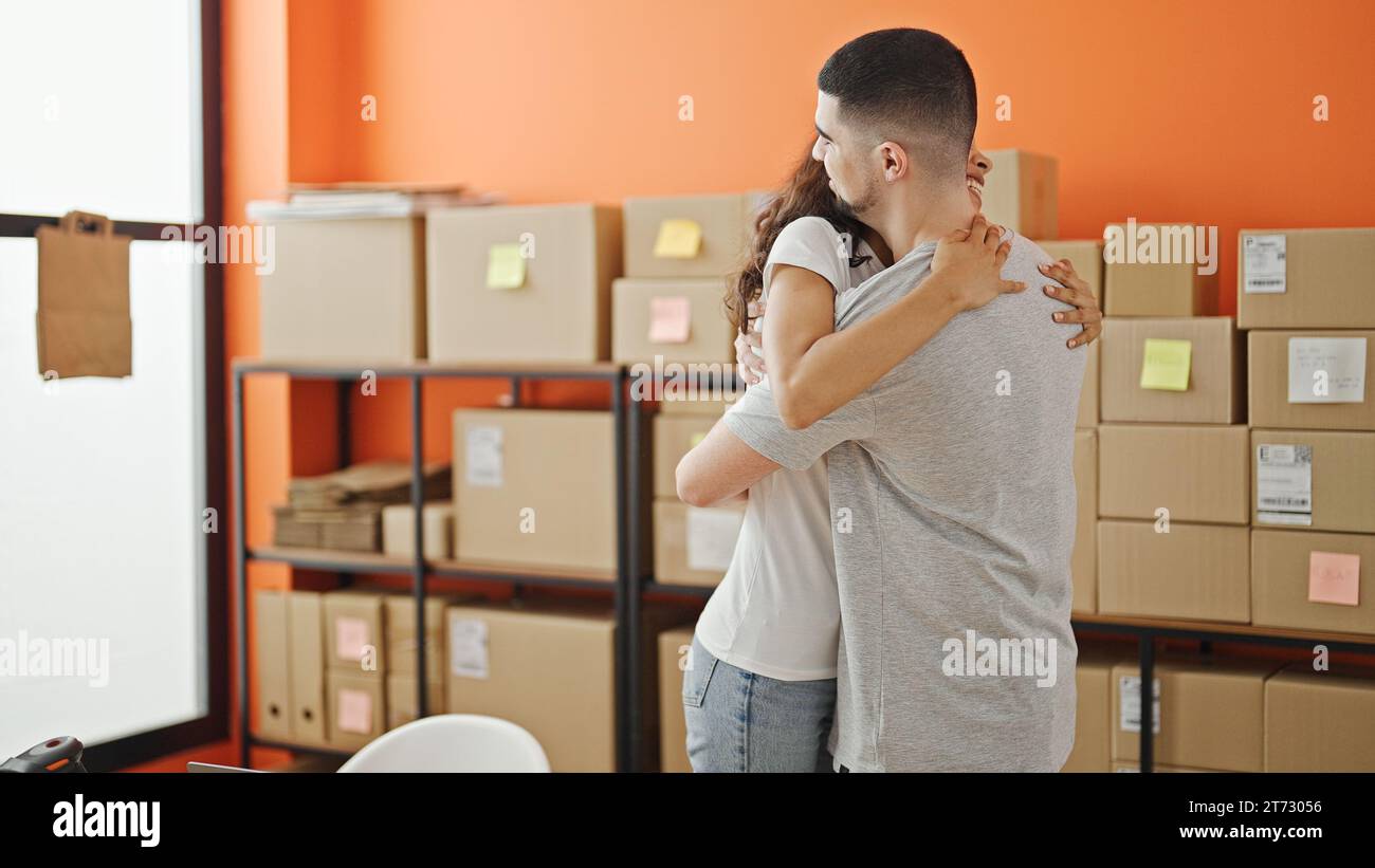 Two smiling workers, man and woman, sharing a heartfelt hug in the ...