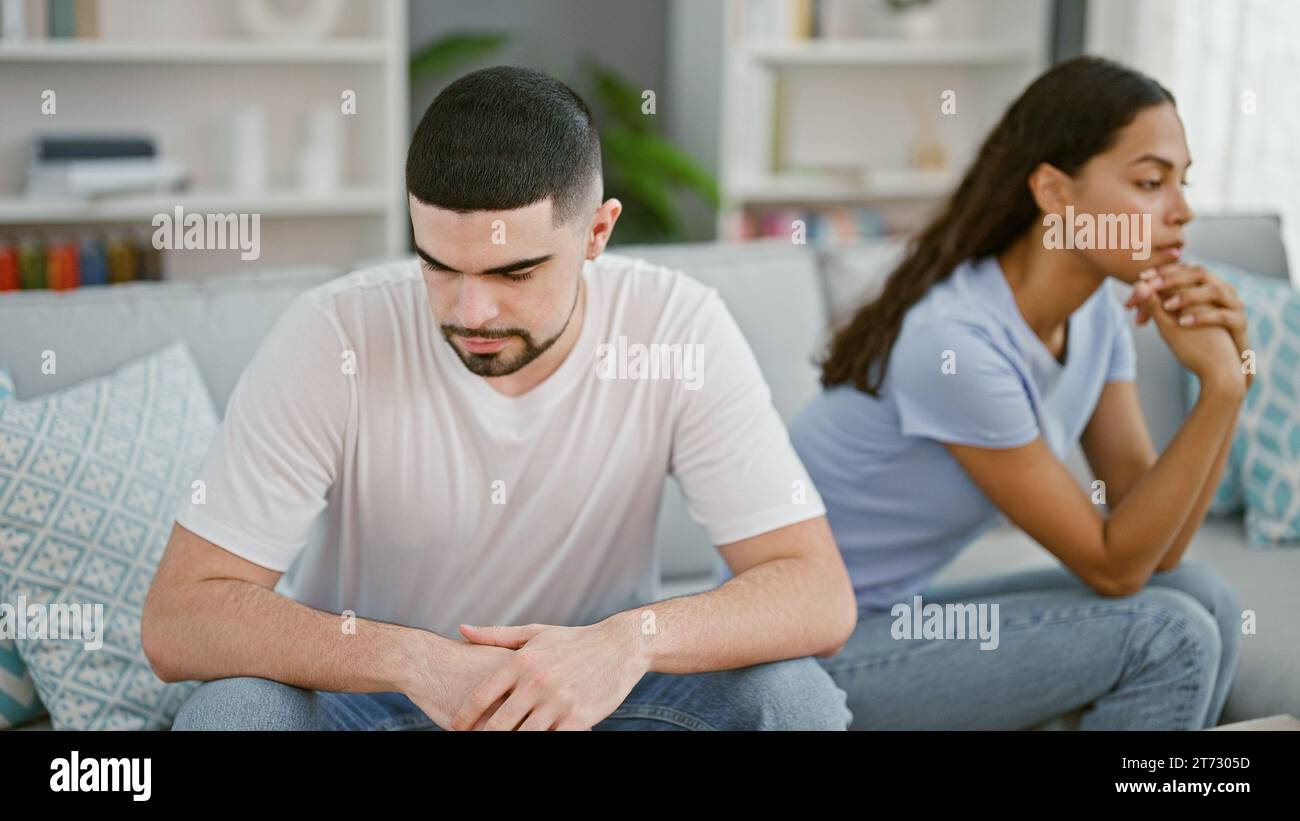 Stressed beautiful couple in a serious disagreement, sitting together ...