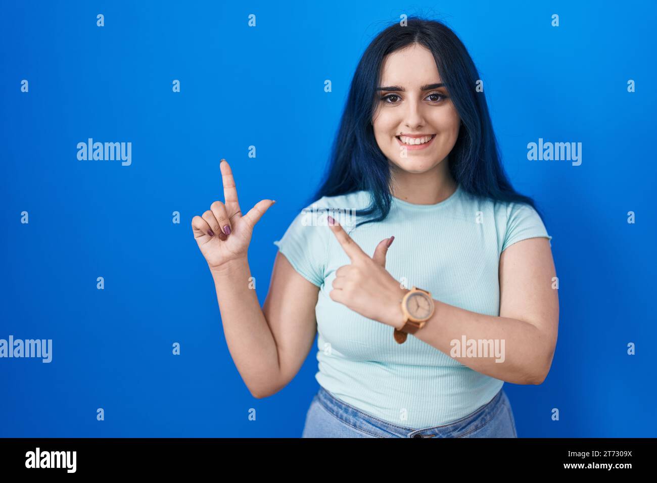 Young Modern Girl With Blue Hair Standing Over Blue Background Smiling 2629