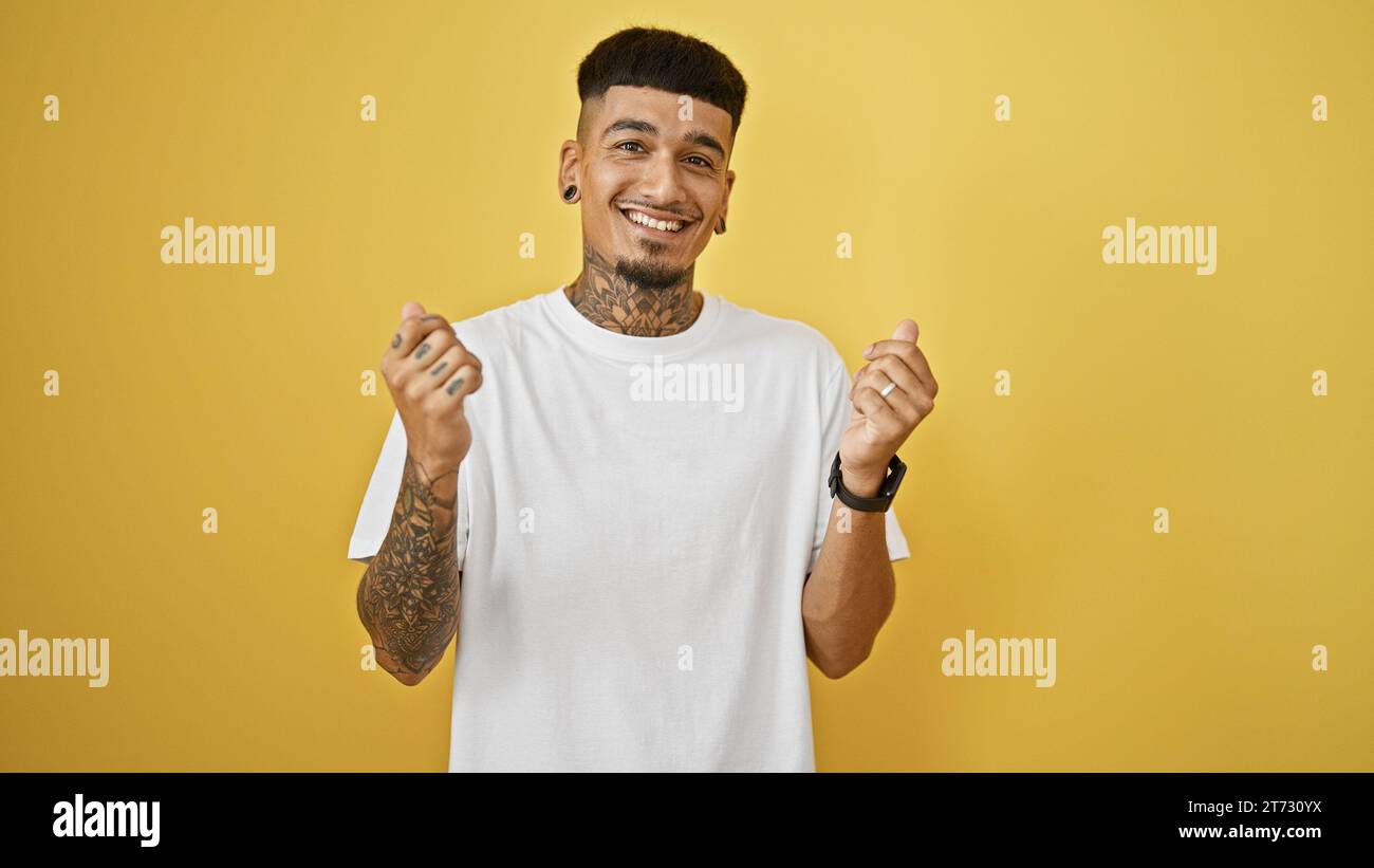 Cheerful young latin man confidently making a money gesture, flawless ...