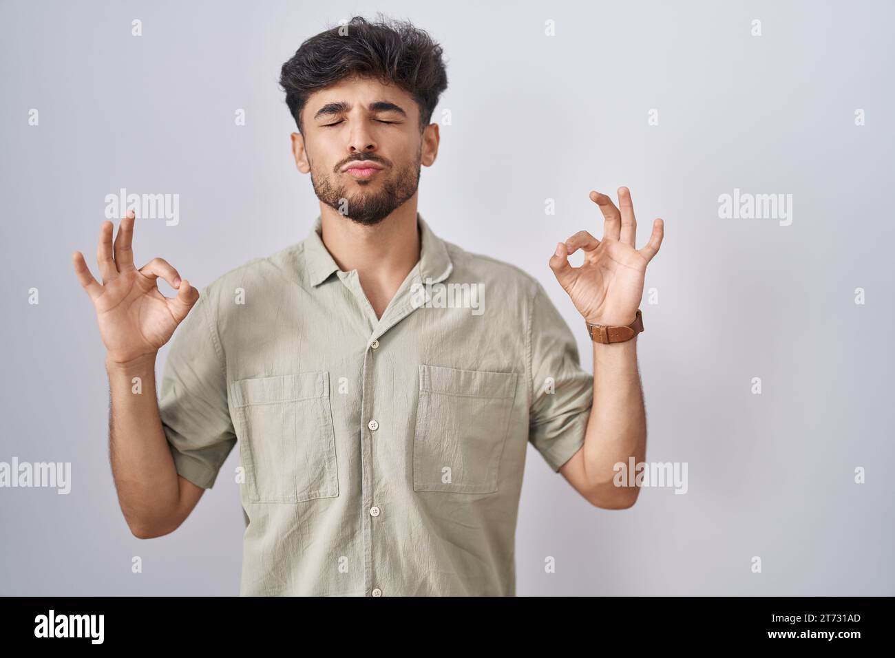 Arab man with beard standing over white background relaxed and smiling ...