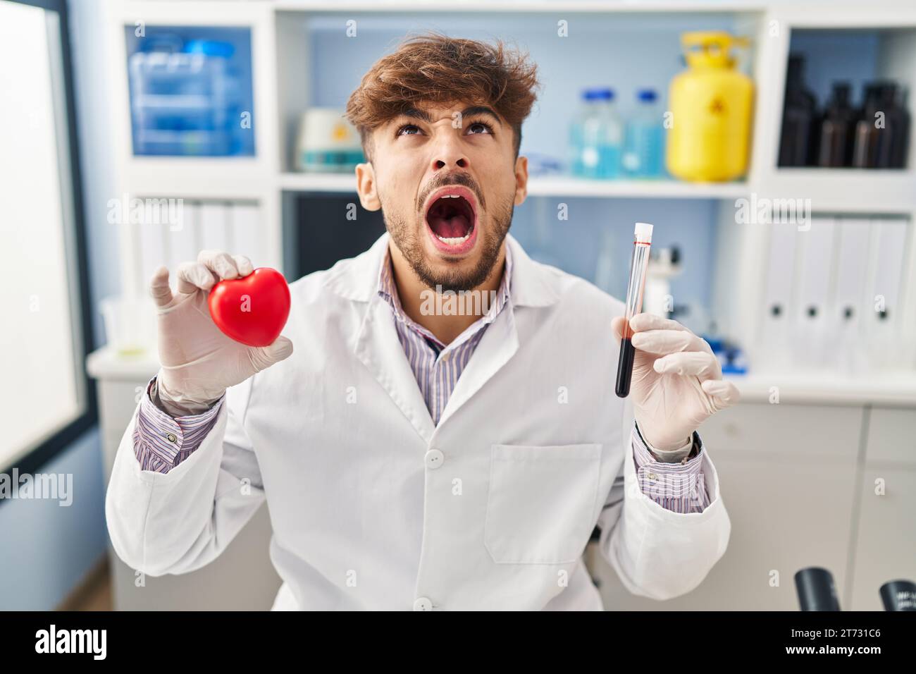 Arab man with beard working at scientist laboratory holding blood ...