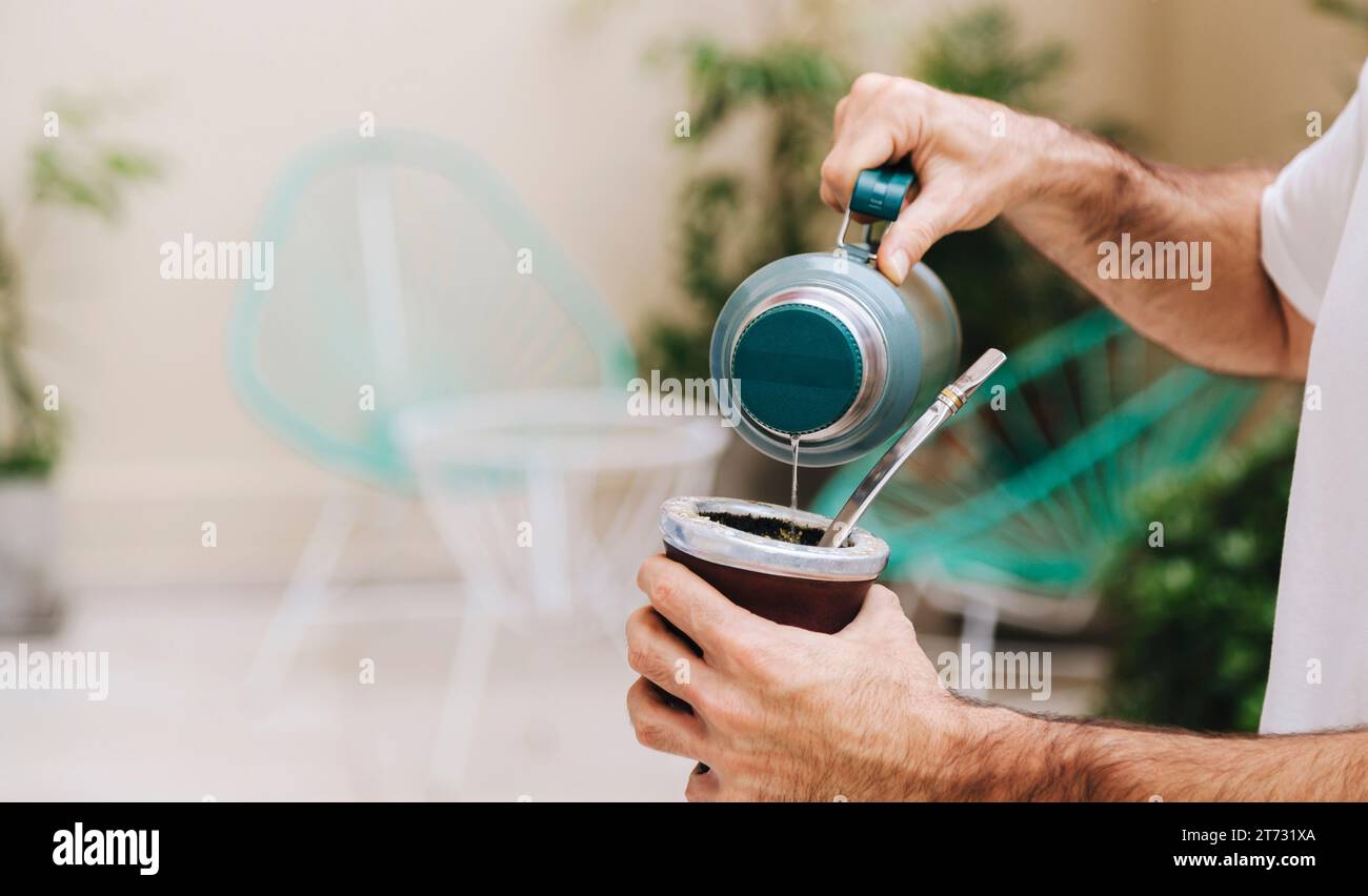 A man pours water from a thermos into a mate. Yerba Mate, traditional ...