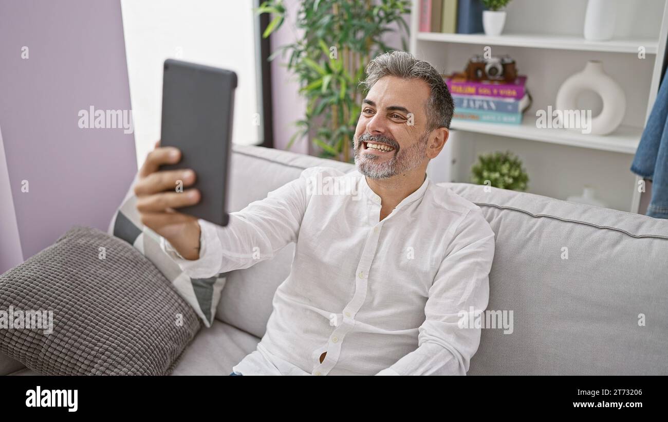 Cheerful young hispanic man with grey hair smiling and having a fun ...