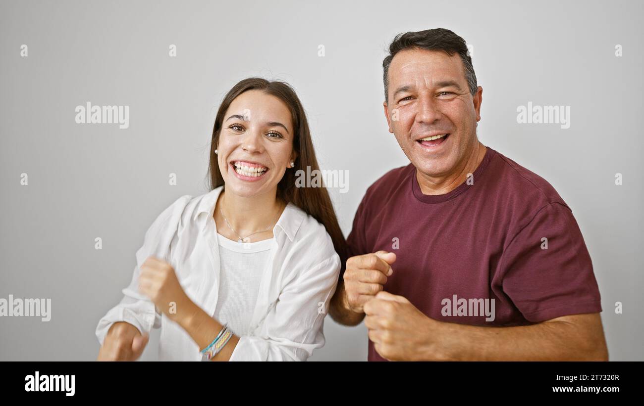 Confident father and daughter sharing a joyful dance, smiling on white ...