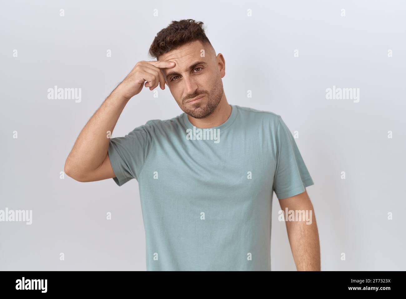 Hispanic man with beard standing over white background pointing unhappy ...