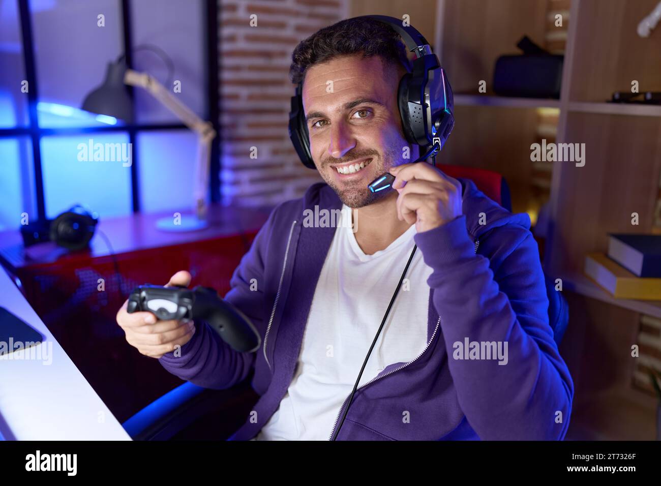 Young hispanic man streamer playing video game using joystick at gaming ...