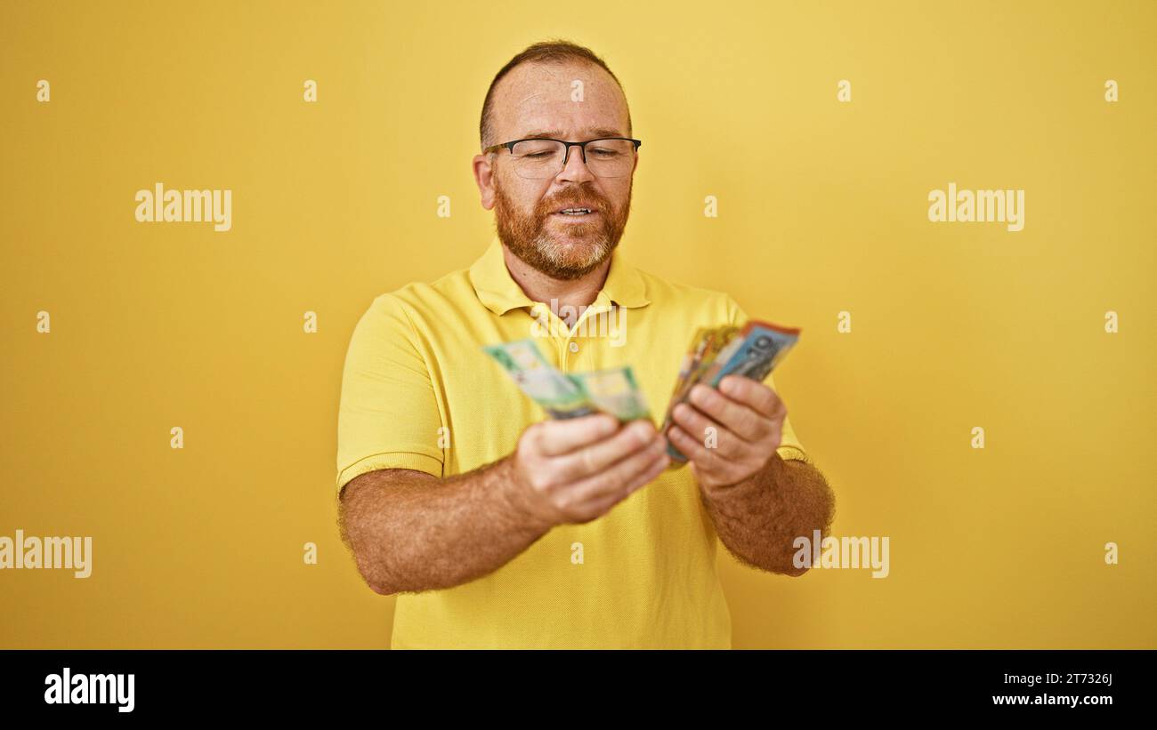 Cheerful caucasian man confidently counting handsome sum of australian ...