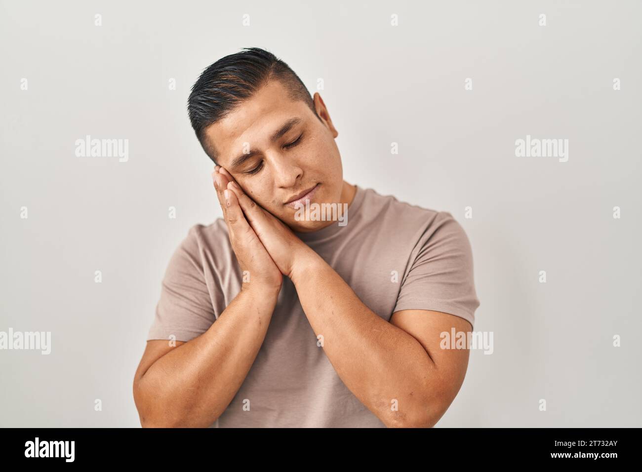 Hispanic young man standing over white background sleeping tired ...