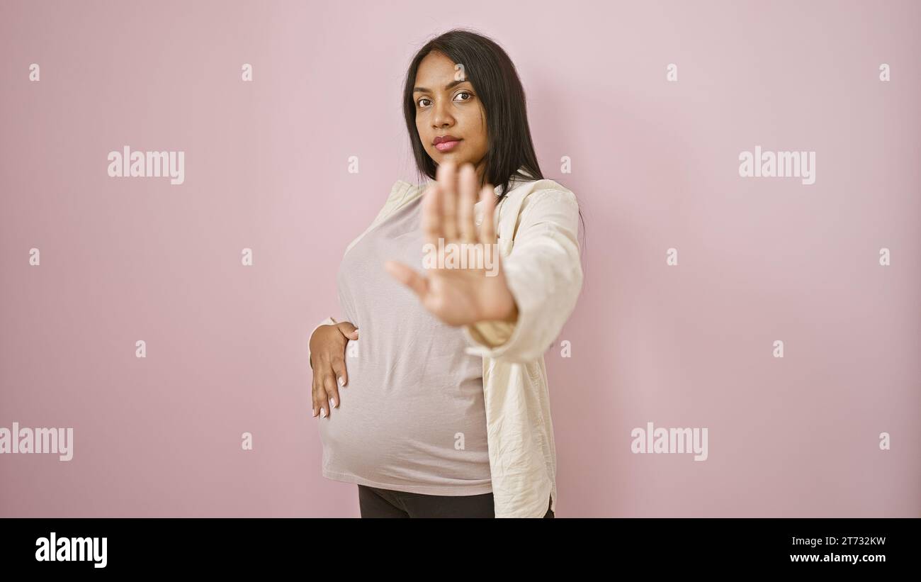 Angry young pregnant woman touching belly, furiously gesturing stop ...