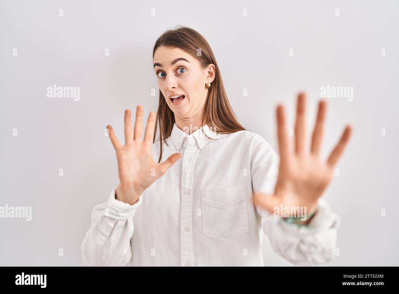 Young caucasian woman standing over isolated background afraid and ...