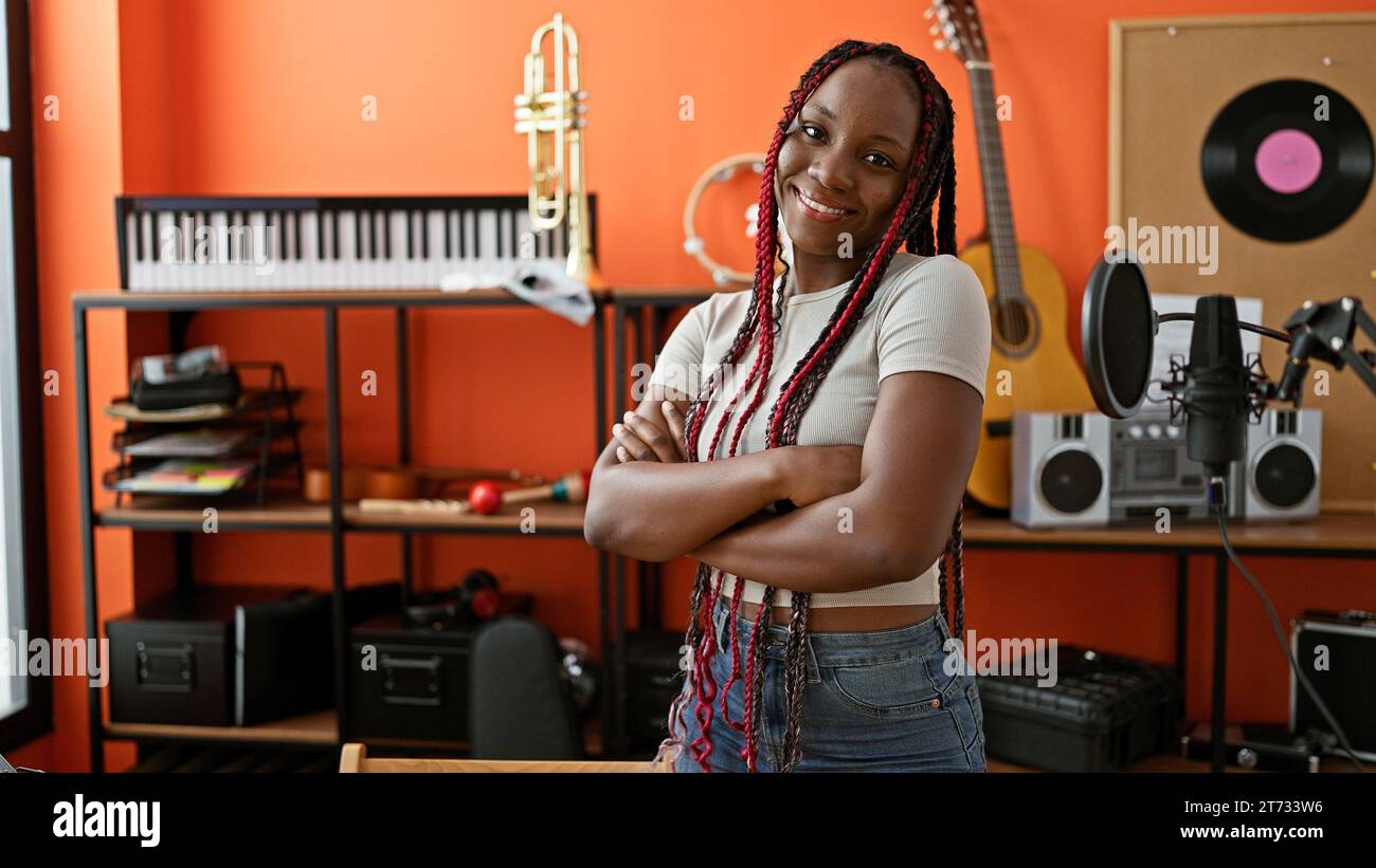 Smiling african american woman musician, arms crossed in relaxed ...