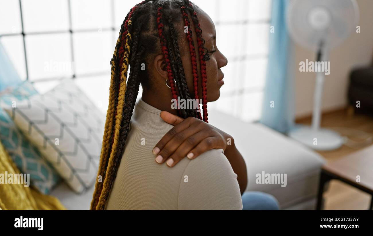 Beautiful african american woman stressed and hurting, sitting on ...