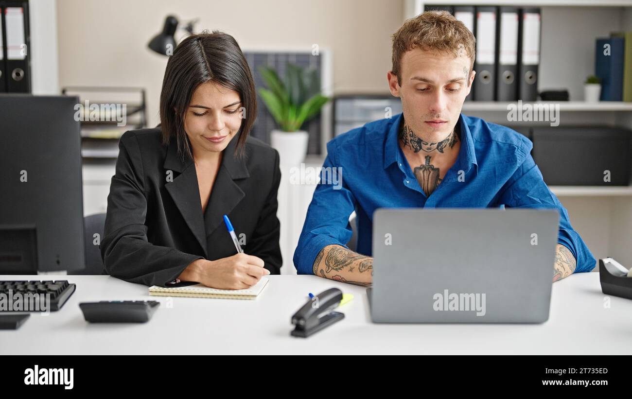 Two business workers using laptop taking notes at the office Stock ...