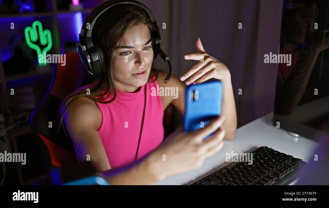 Attractive young hispanic woman streamer fully immersed in an engaging ...