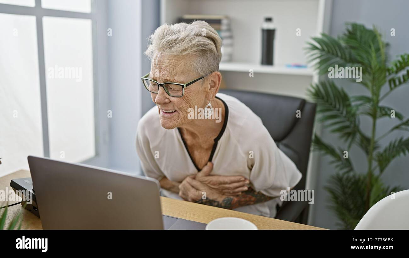 Stressed, overworked grey-haired senior business woman suffers heart ...