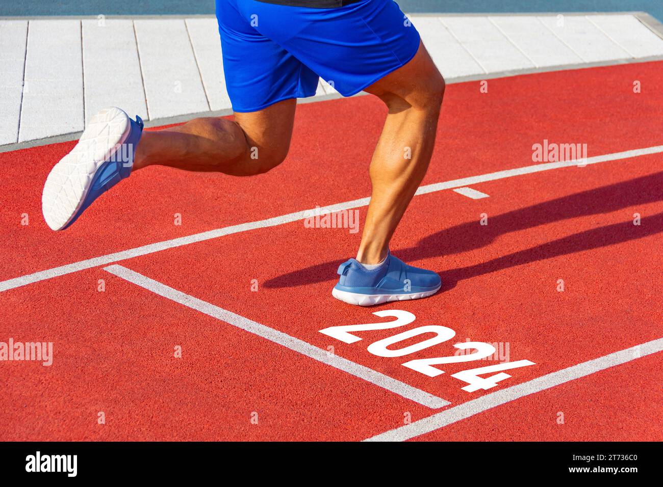Runner crosses the finish line on a red treadmill with the numbers 2024 ...