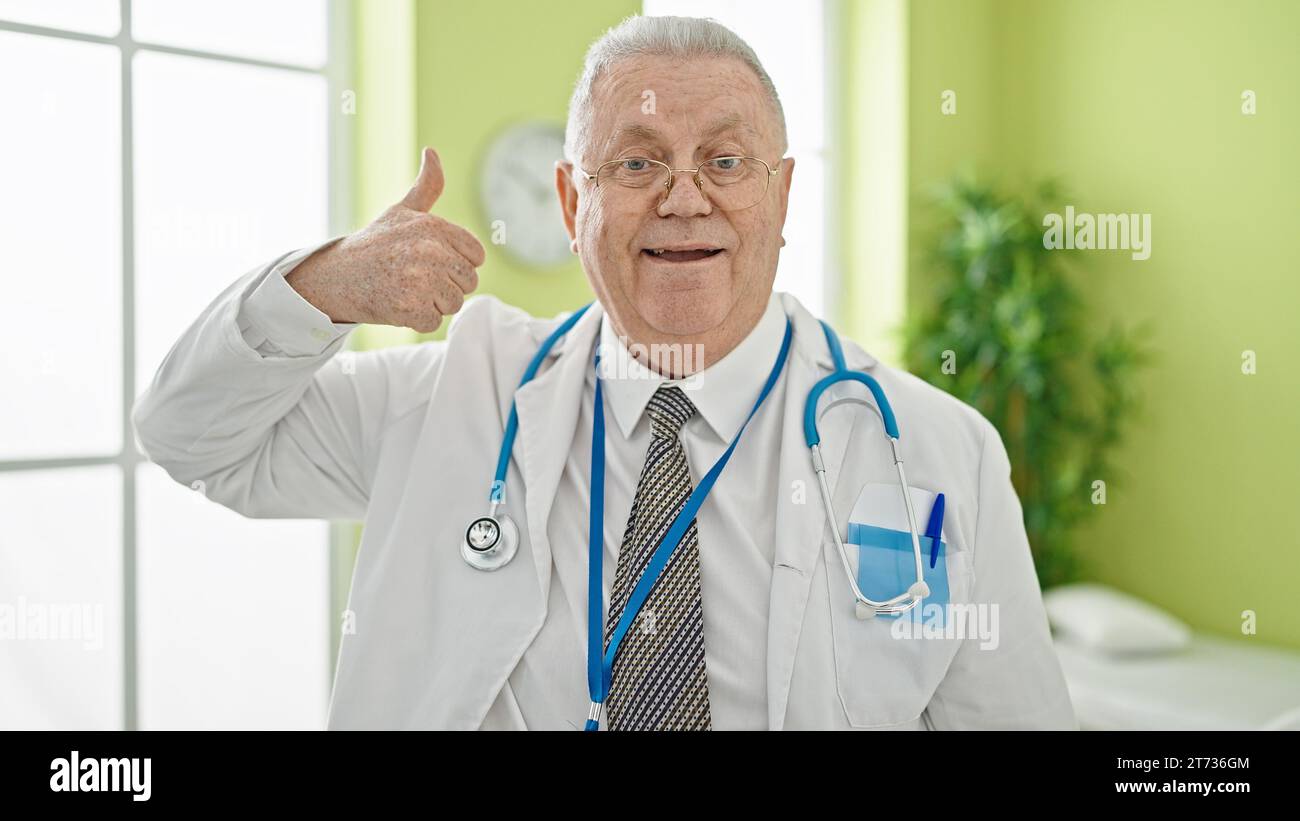 Middle age grey-haired man doctor doing thumb up at clinic Stock Photo ...