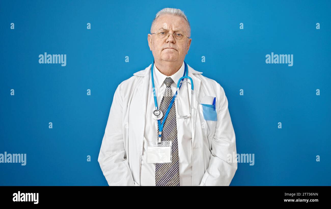 Middle age grey-haired man doctor standing with serious expression ...