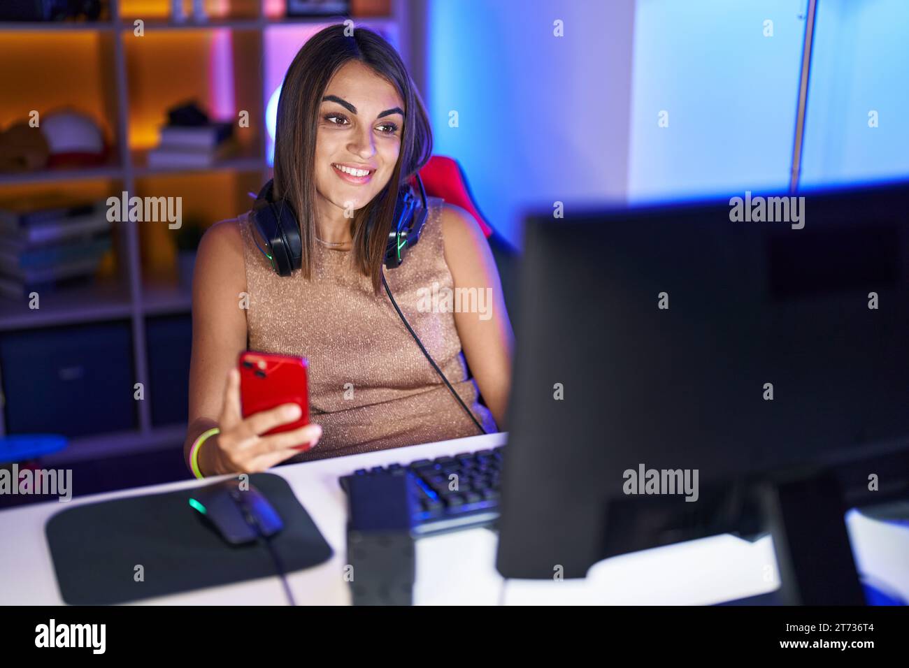 Young beautiful hispanic woman streamer using computer and smartphone ...