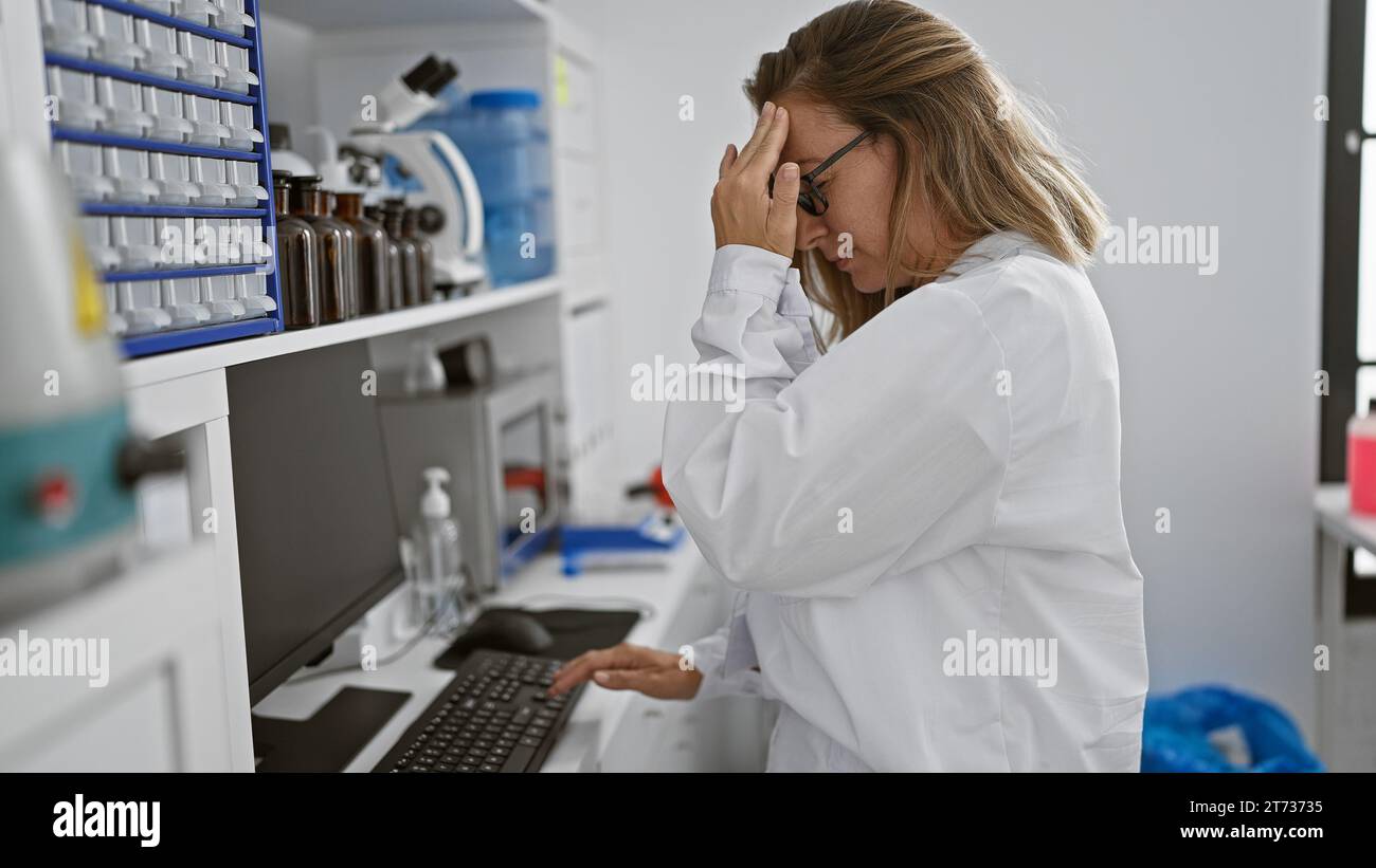 Exhausted young blonde woman scientist feeling the stress from working ...