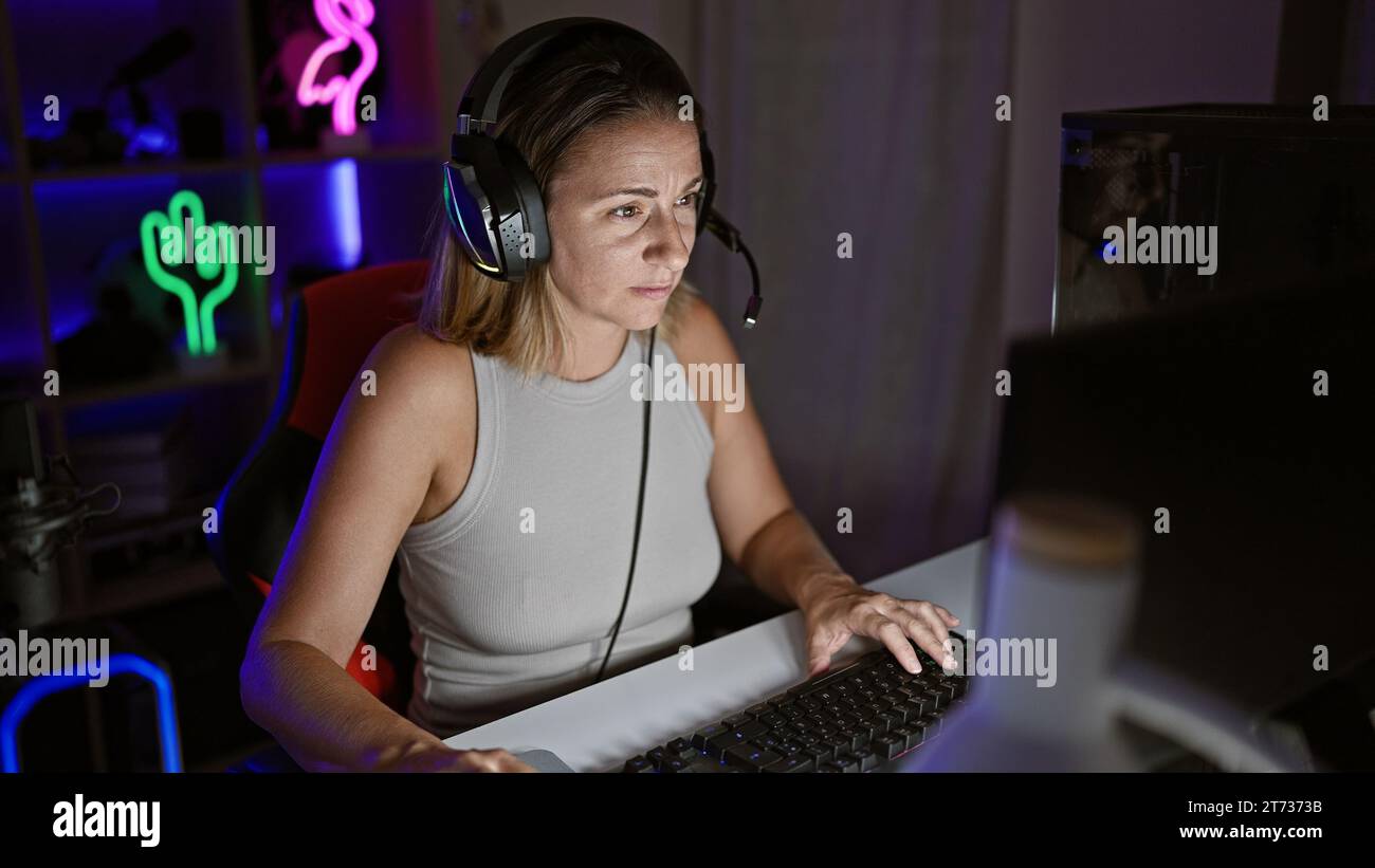 Attractive young blonde woman streamer, locked in her gaming room ...