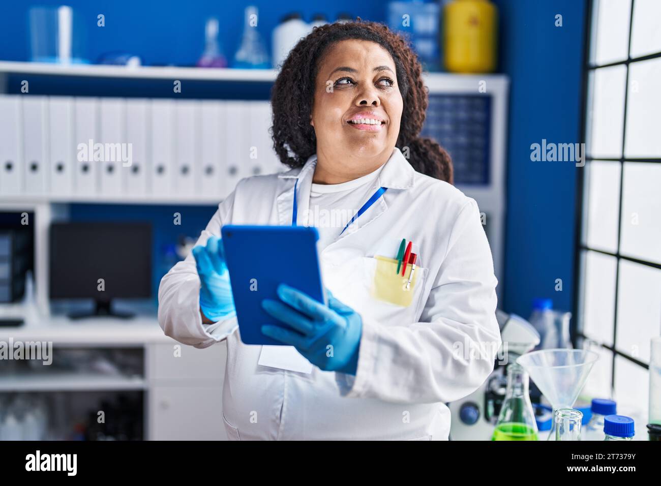 African american woman scientist smiling confident using touchpad at laboratory Stock Photo - Alamy