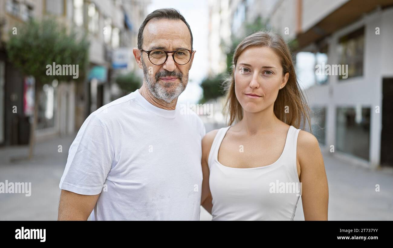 Father and daughter together, standing on the street, their faces ...