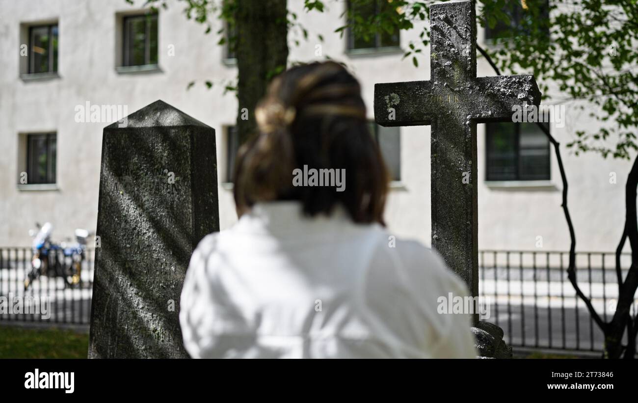 Beautiful young hispanic woman praying and mourning by tombstone at ...