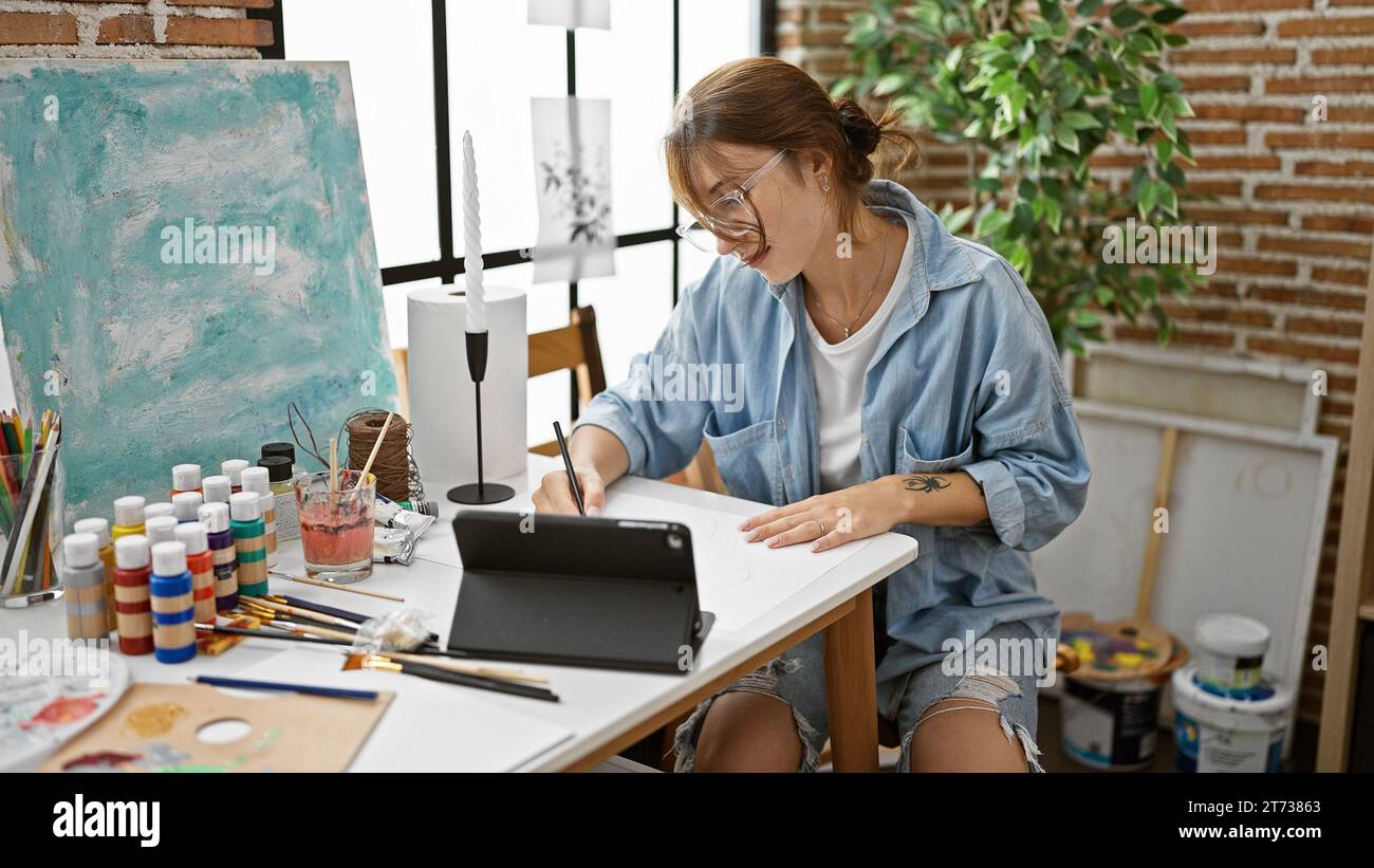 Young woman artist drawing on paper using touchpad at art studio Stock ...