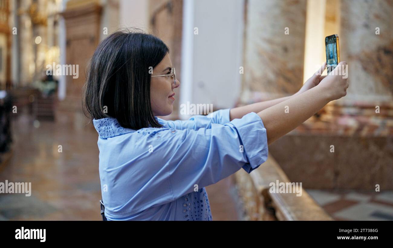 Young beautiful hispanic woman visiting church recording with ...