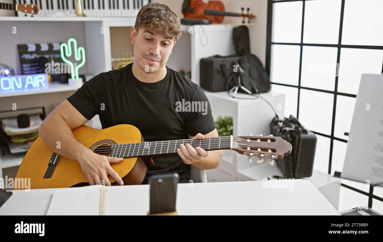Smiling young hispanic man musician, charmingly strumming classic ...