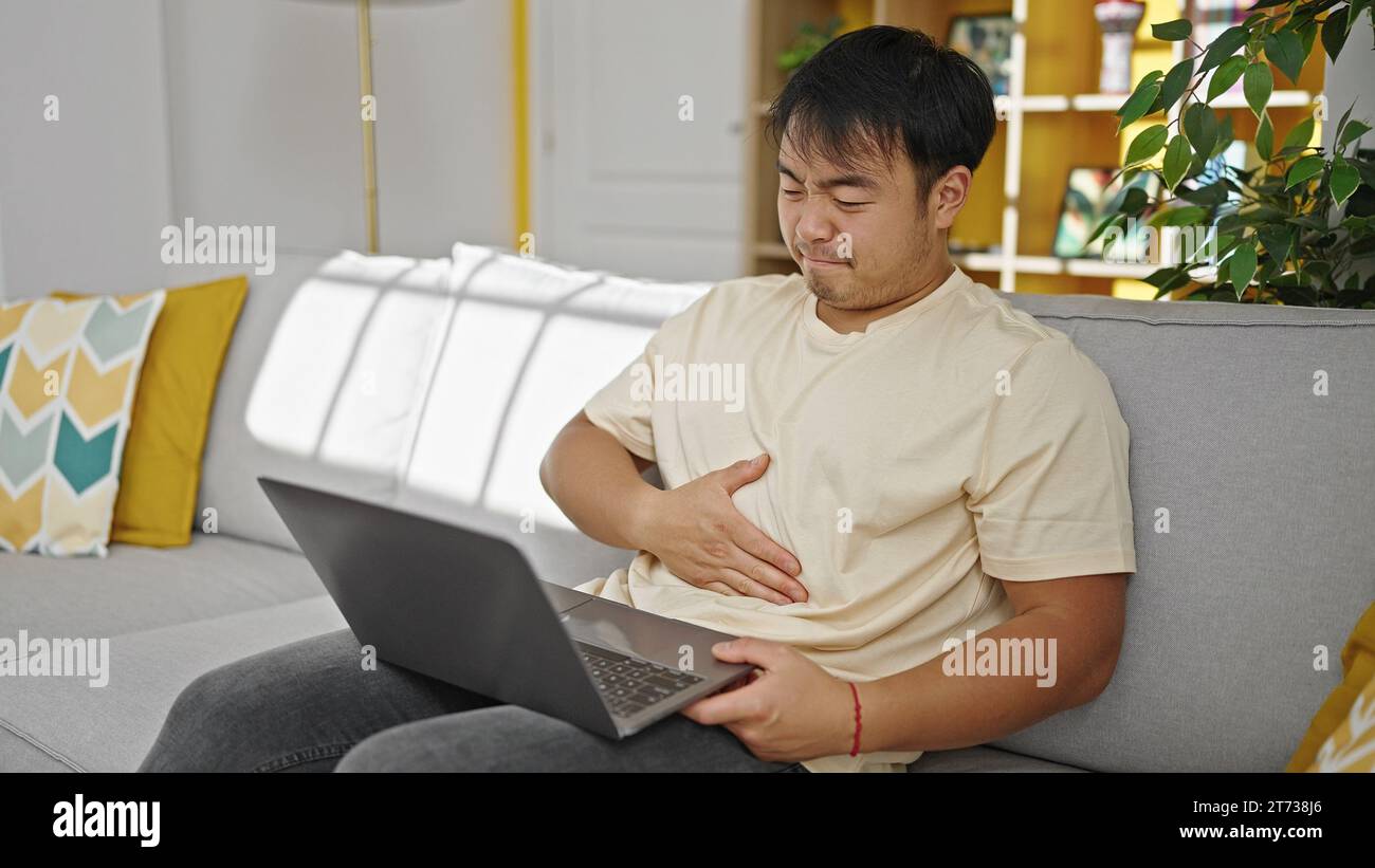 using laptop suffering for hungry at home Stock Photo - Alamy