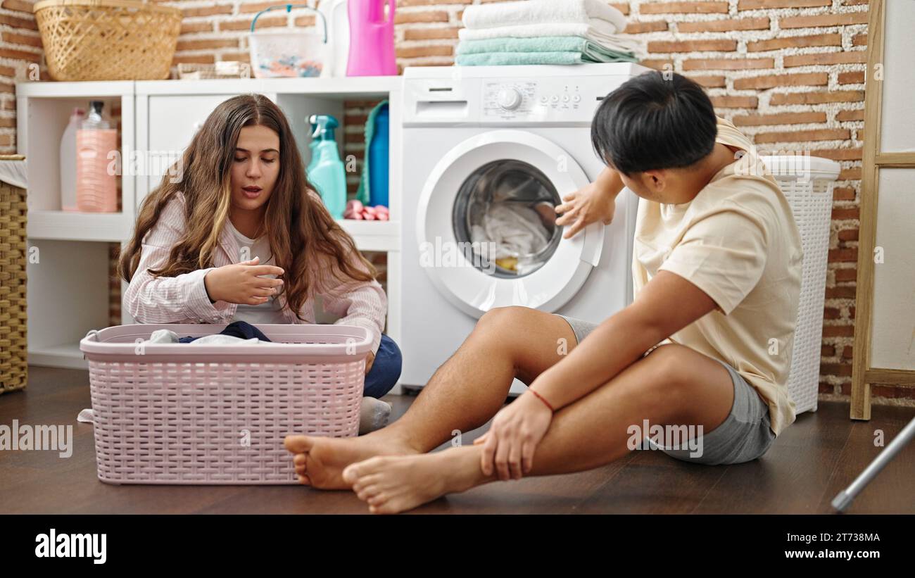 Man and woman couple washing clothes at laundry room Stock Photo - Alamy