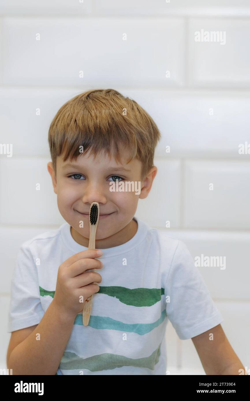 cute 5 years old boy brushing teeth with bamboo tooth brush with black ...