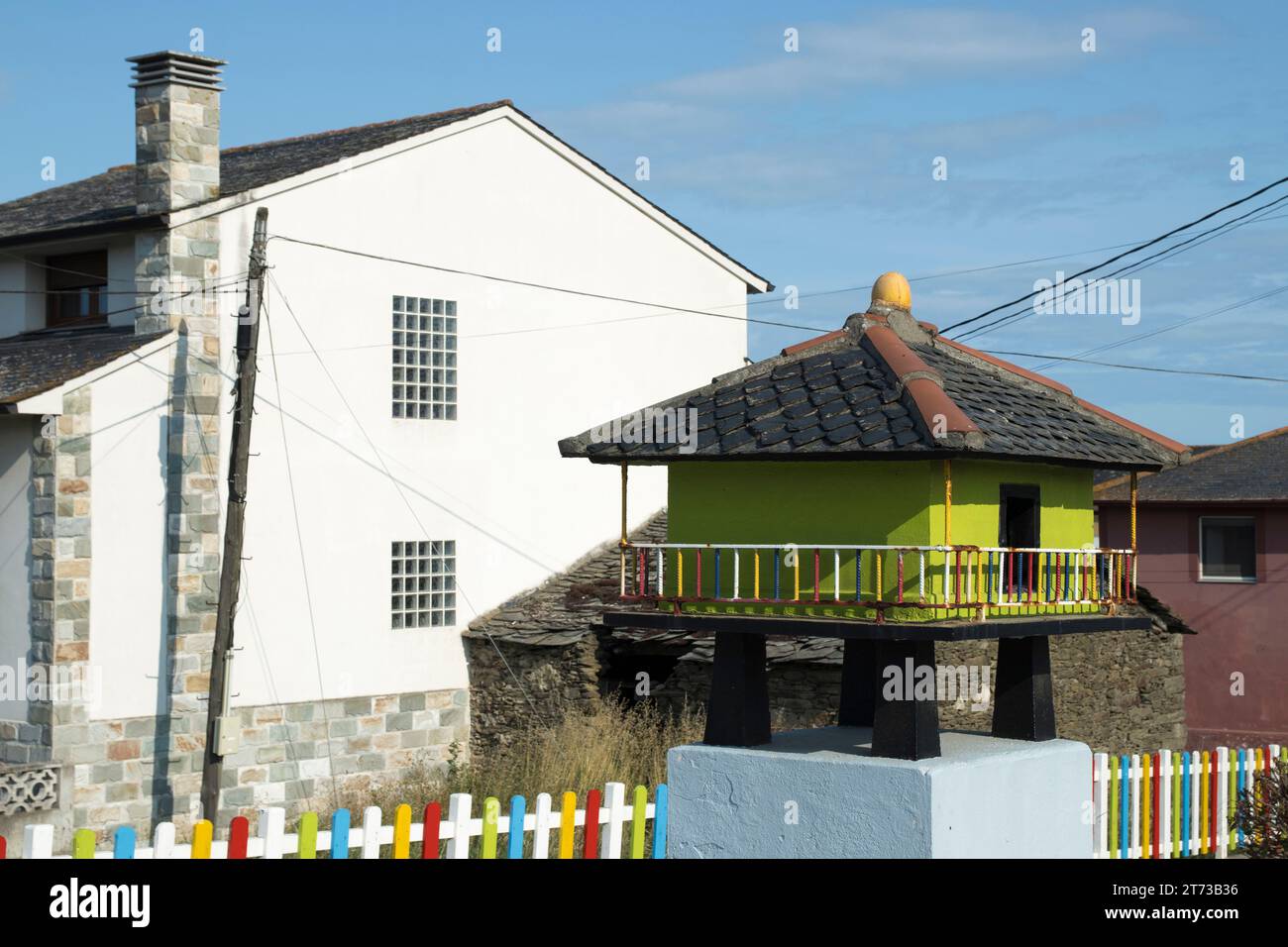 house with a colorful balcony and a stone chimney, surrounded by a ...