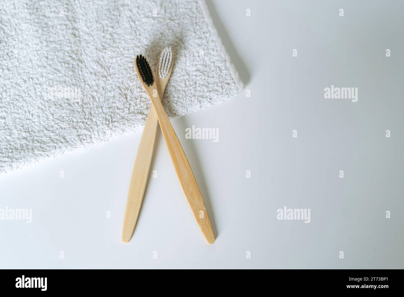 two toothbrushes on white terry towel on white background. Eco friendly ...